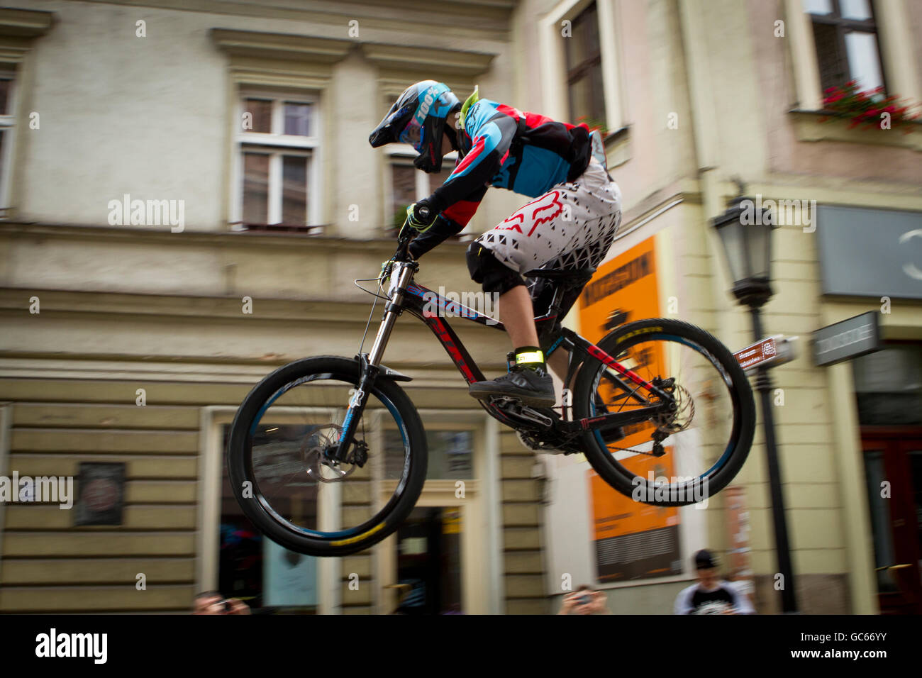 Downhill city tour. Biker jumps over the ramp during mountain bike race ...