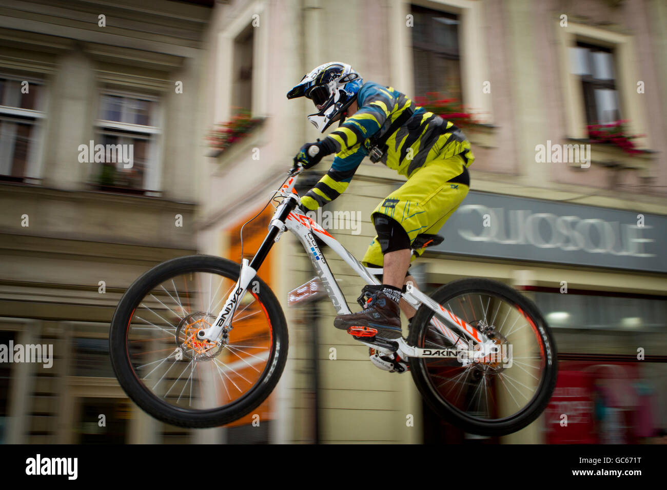 Downhill city tour. Biker jumps over the ramp during mountain bike race ...