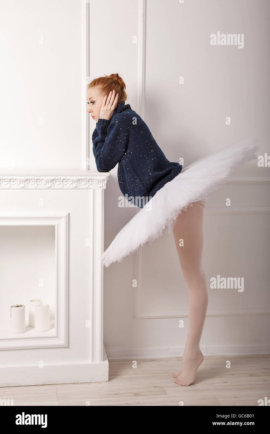 Pretty young ballerina sad fireplace. A girl wearing a tutu and a black ...