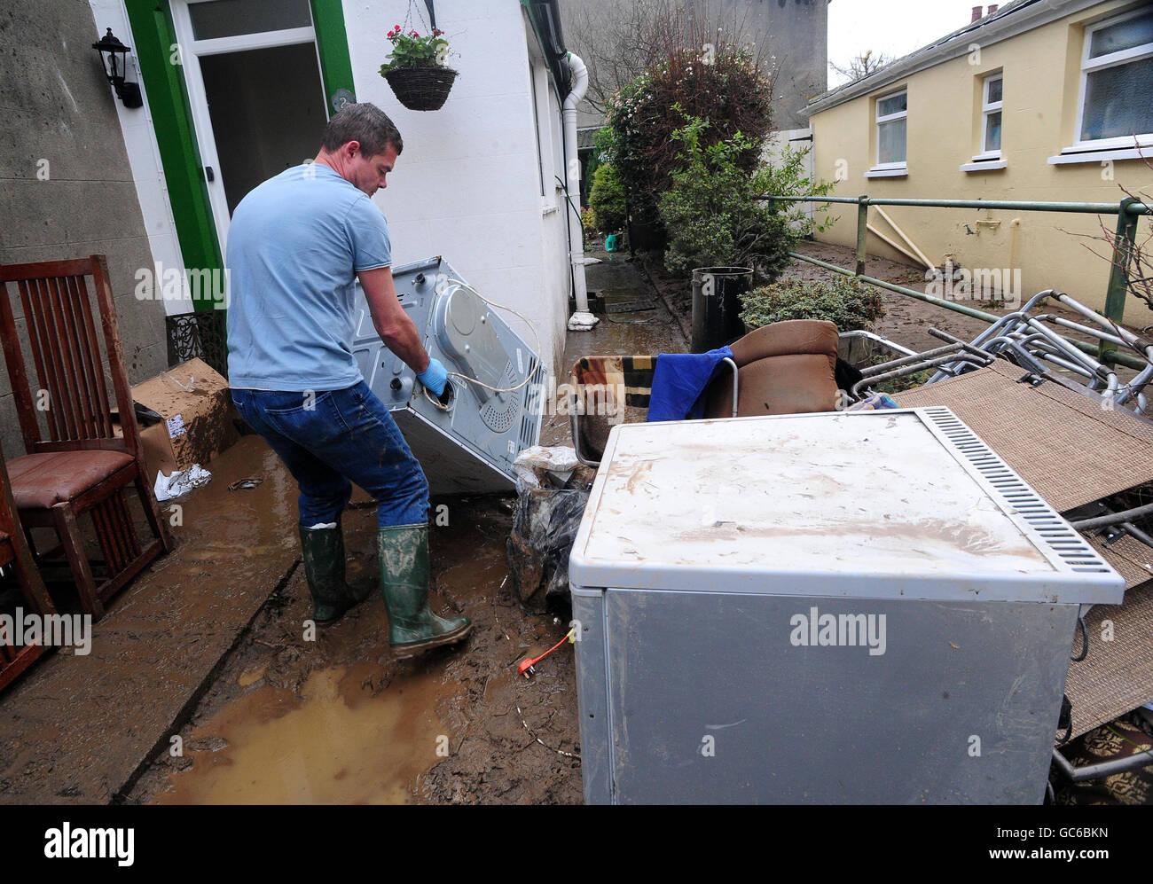 Ken Fisher cleans the debris from his house in Cockermouth after flood ...