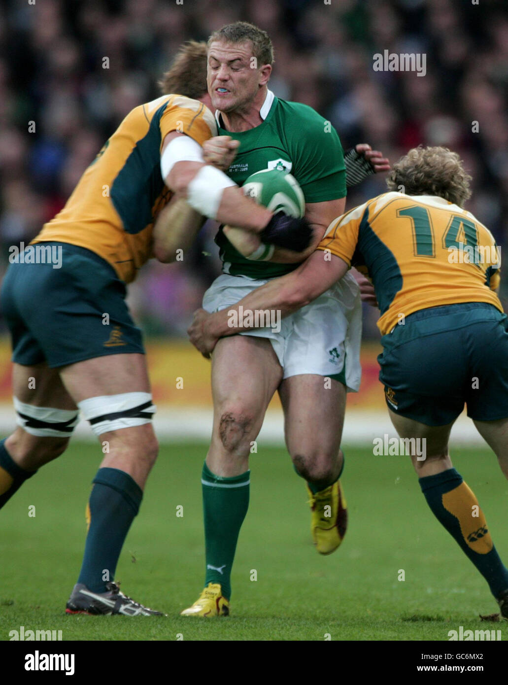 Ireland's Jamie Heaslip (Centre) is tackled by Australia's Rocky Elsom ...