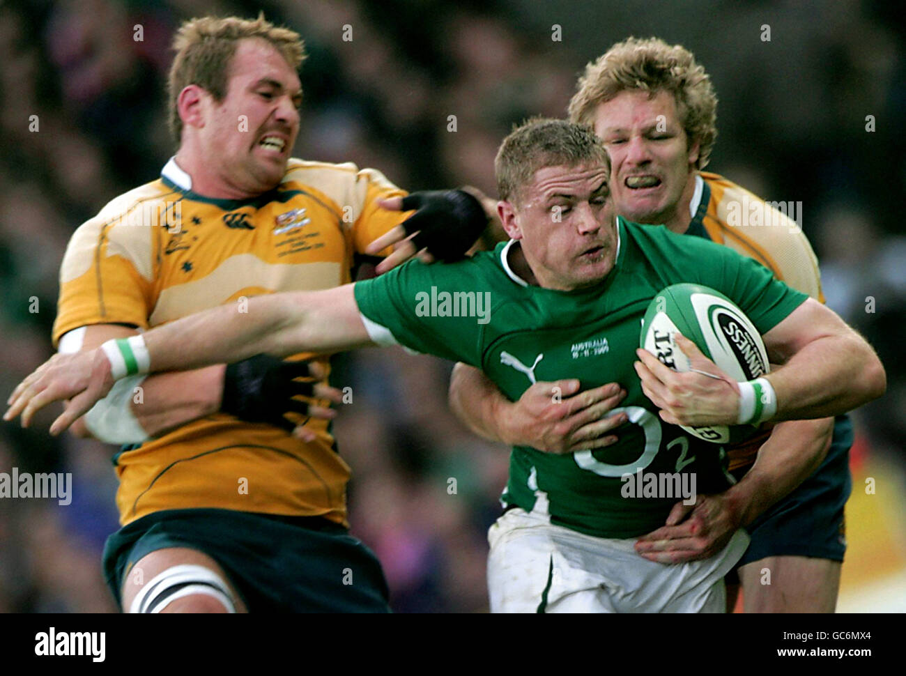 Ireland's Jamie Heaslip (Centre) is tackled by Australia's Rocky Elsom ...