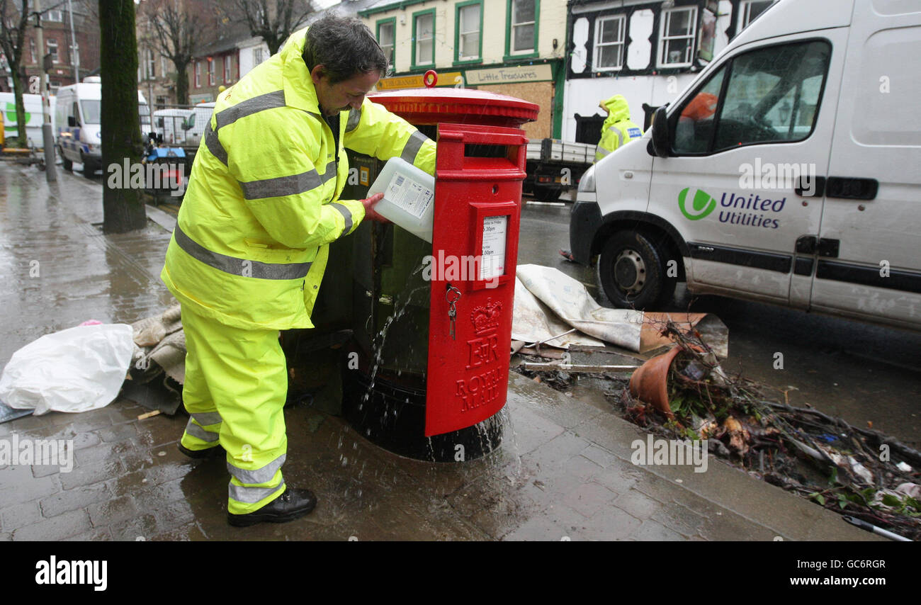 A member of staff from Royal Mail cleans a post box in Cockermouth town ...