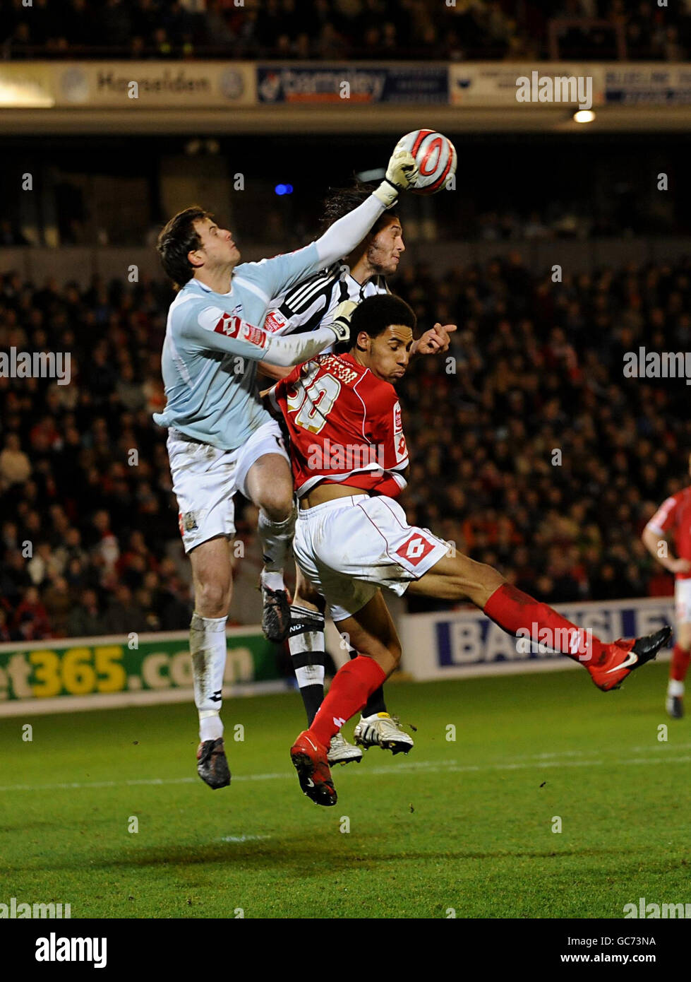 Barnsley's goalkeeper Luke Steele punches clear under pressure from ...