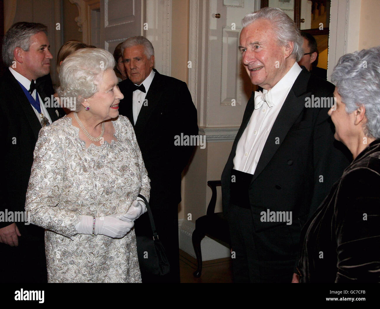 Queen Elizabeth II is greeted by conductor Sir Colin Davis as she ...