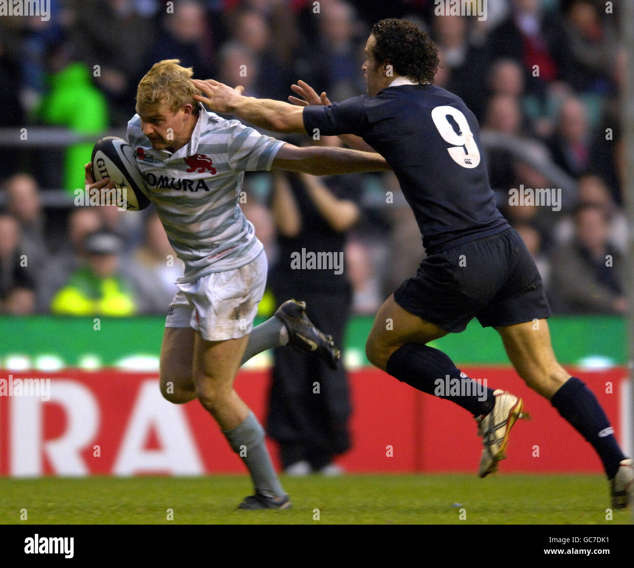Cambridge University's Jamie Hood (left) runs past a challenge from ...