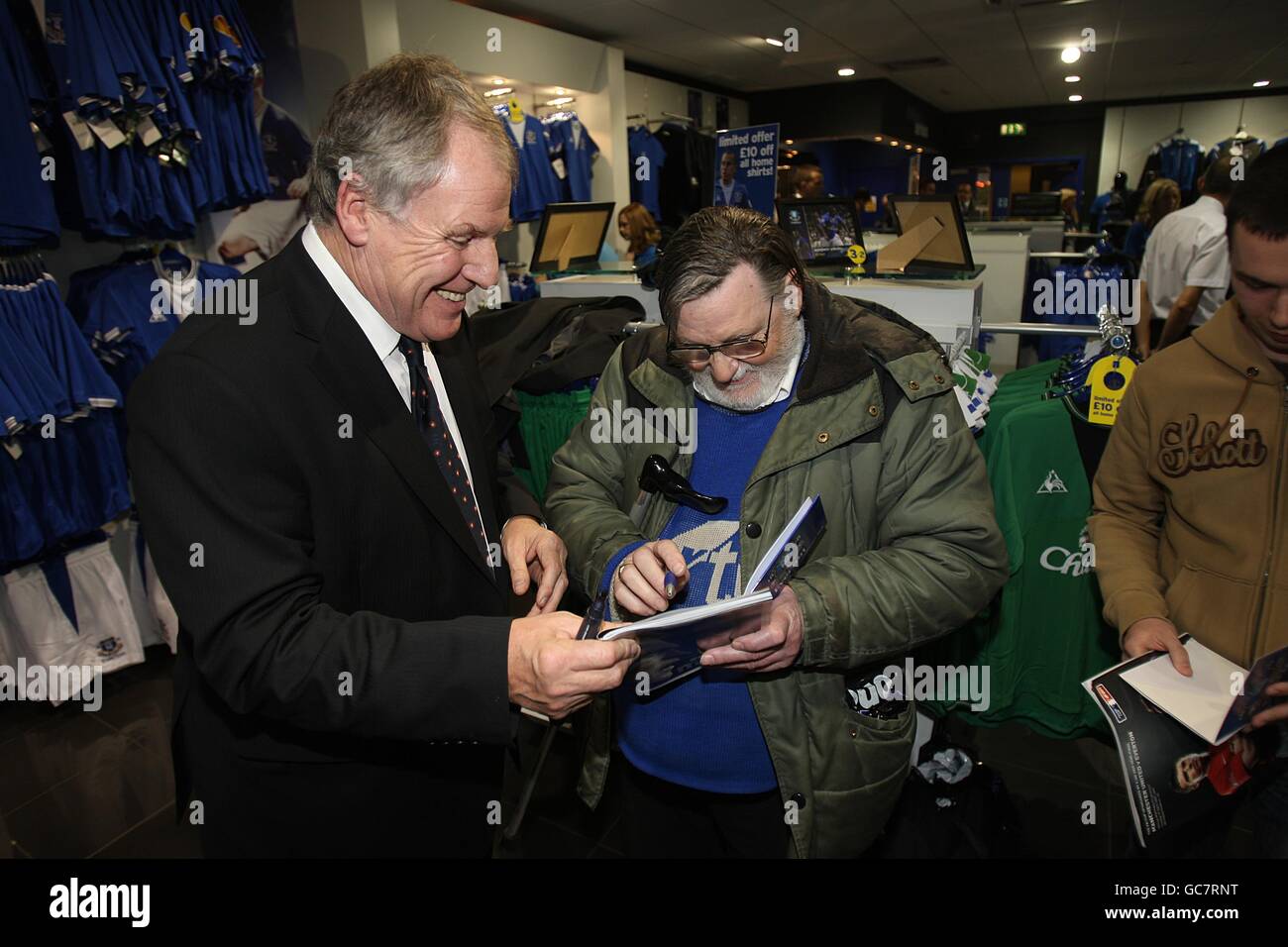 Former Everton player and manager Joe Royle (left) signs autographs for ...