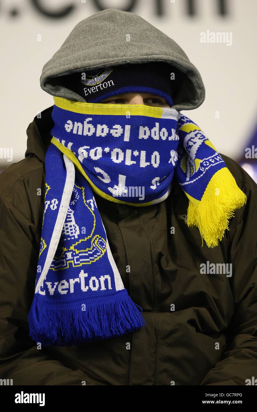 A fan shelters from the cold in the stands hi-res stock photography and ...