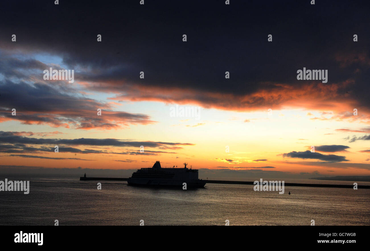 A DFDS Seaways ferry arrives at the mouth of the Tyne during sunrise at ...