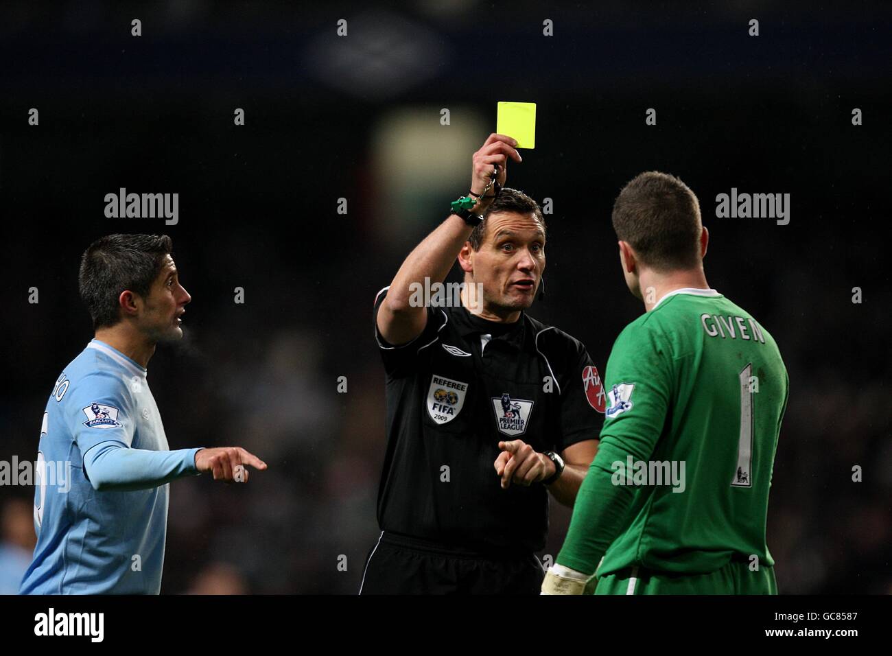 Manchester City goalkeeper Shay Given (right) is shown the yellow card ...