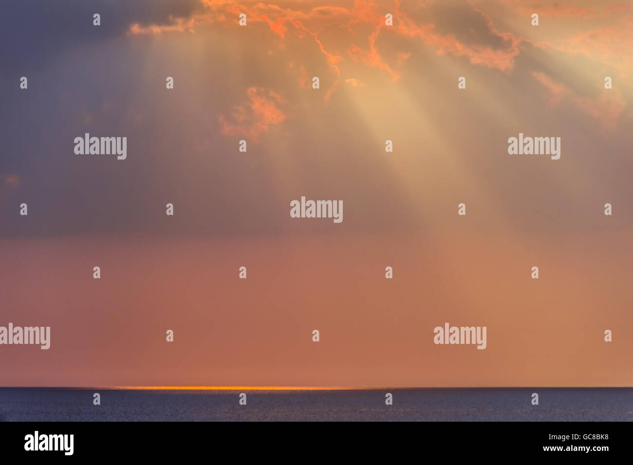 Nice rays of evening sun over sea with clouds Stock Photo - Alamy