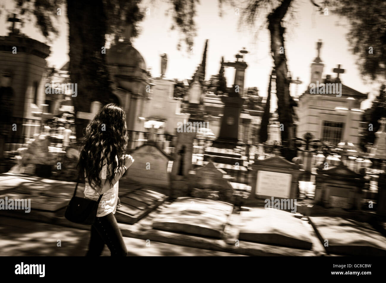 a young woman walking through the cemetery Stock Photo - Alamy