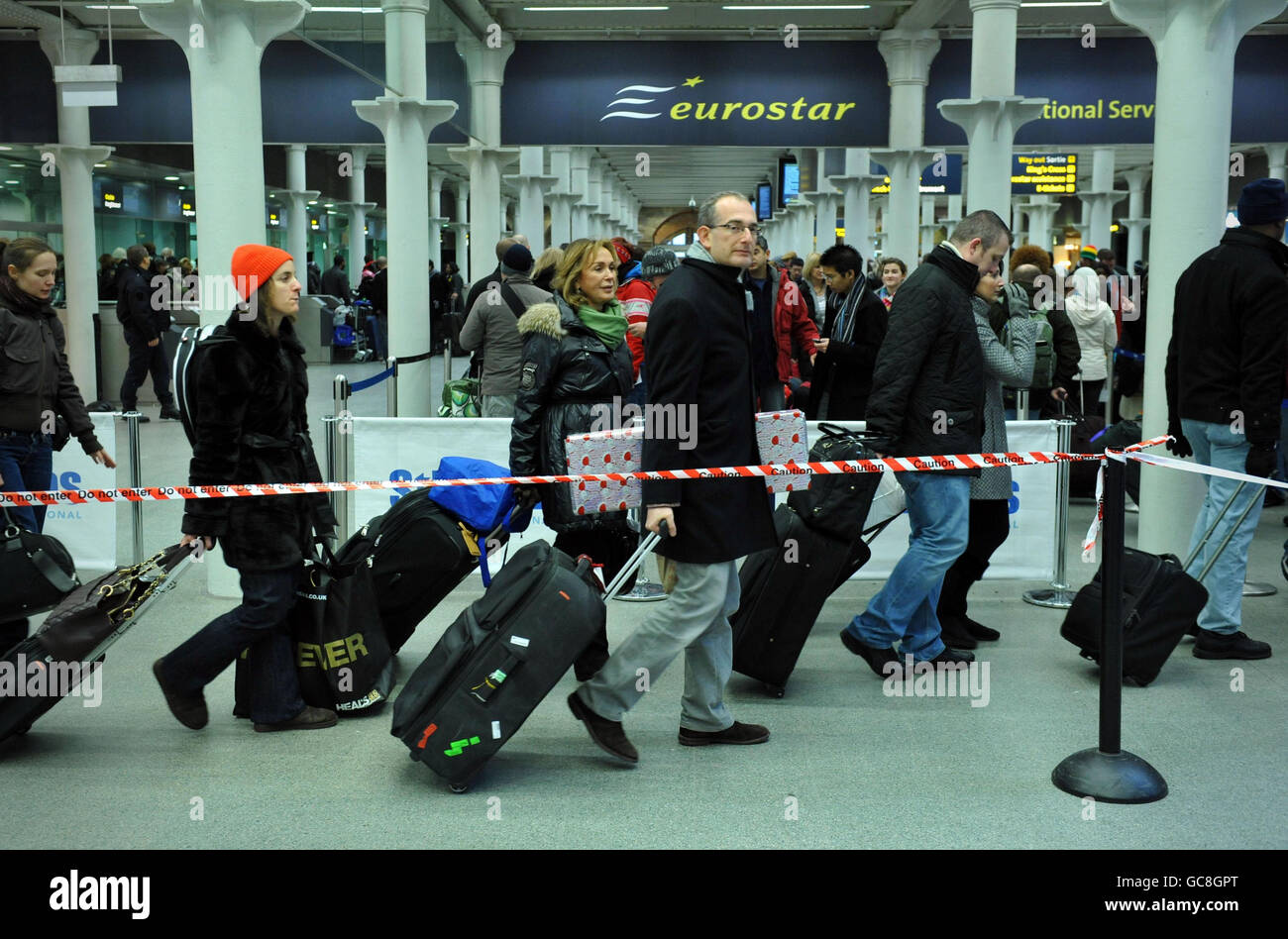 A passenger carries a Christmas present in the queue for Eurostar ...