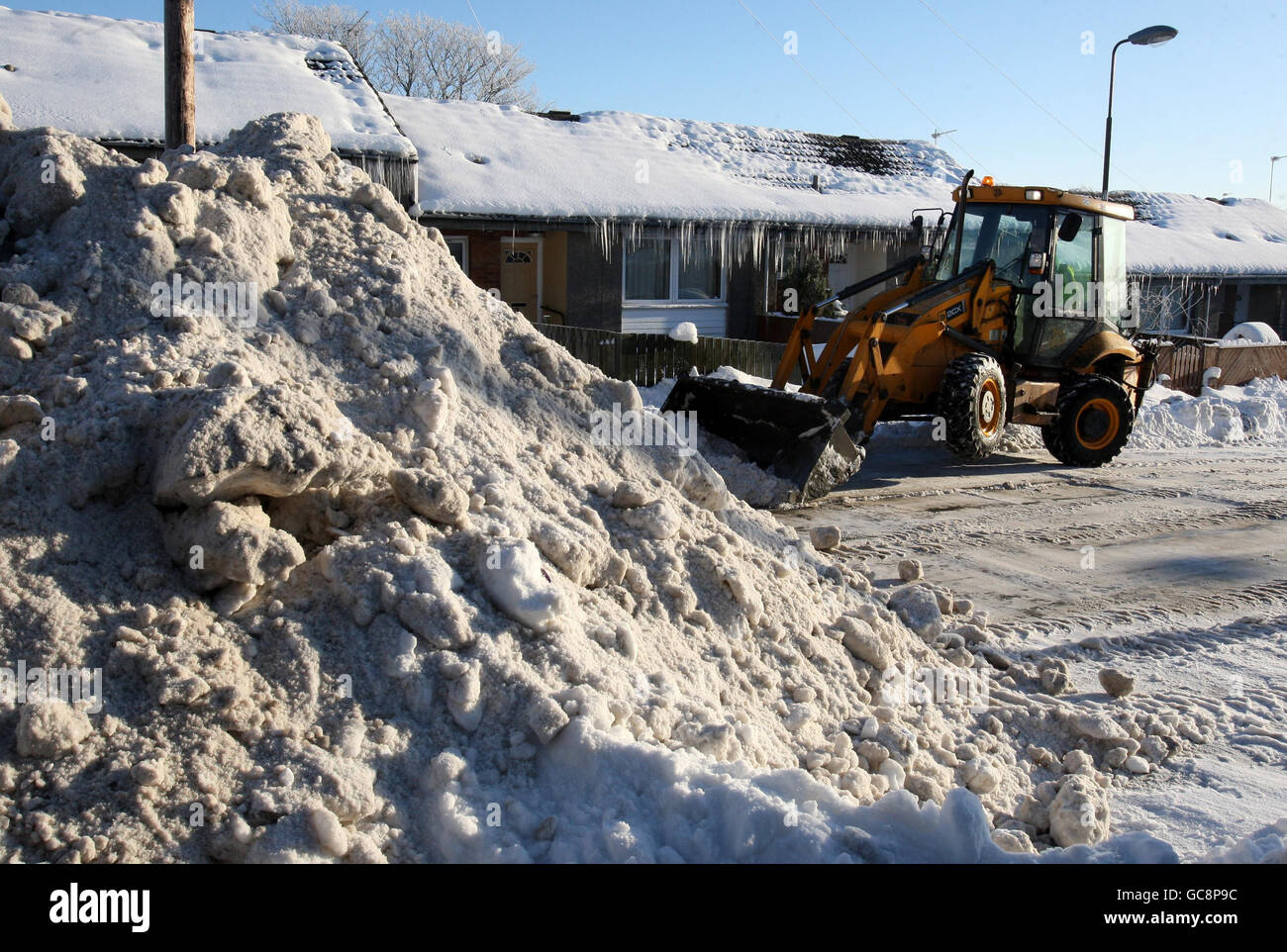 A digger clears snow off the streets of Longridge, West Lothian, as ...