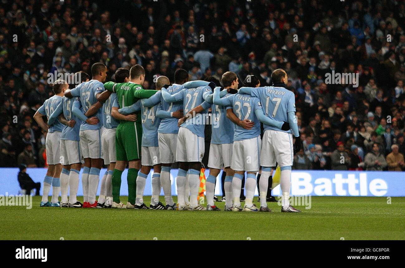 The Manchester City players stand side by side as they take part in the ...