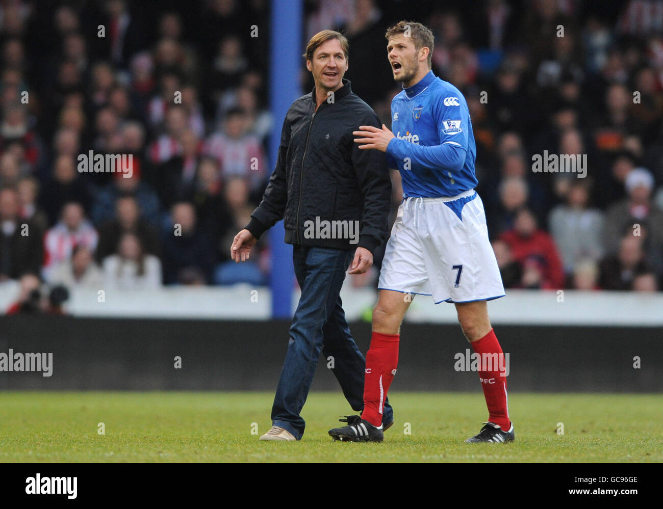 A Portsmouth fan is calmed down by Hermann Hreidarsson after invading ...