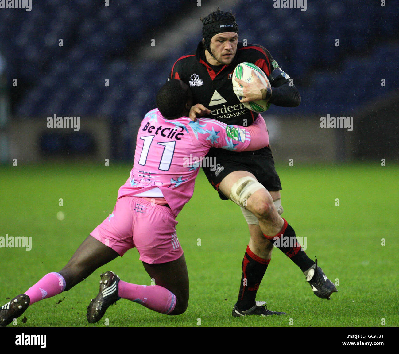 Edinburgh's Alan MacDonald (right) runs through a challenge by Stade's ...