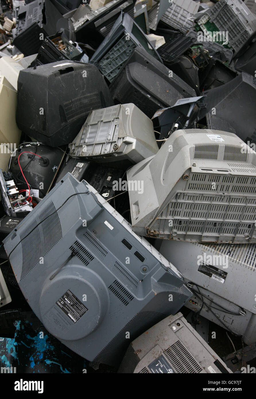 Old television sets and computer monitors are piled high at recycling ...