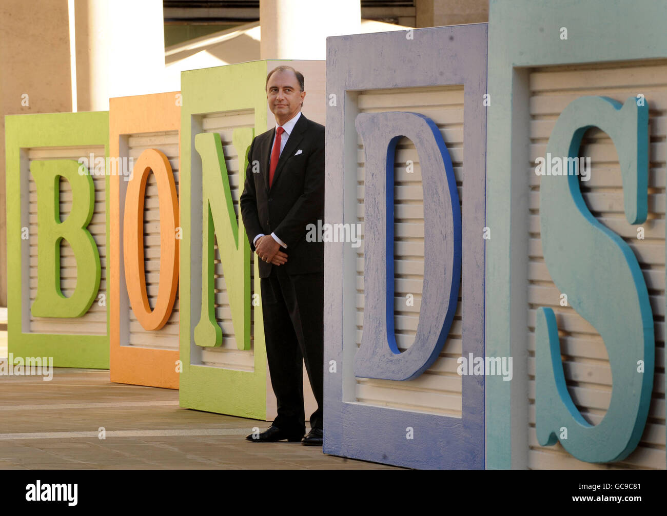Chief Executive of the LSE, Xavier Rolet, poses bedside signage outside ...