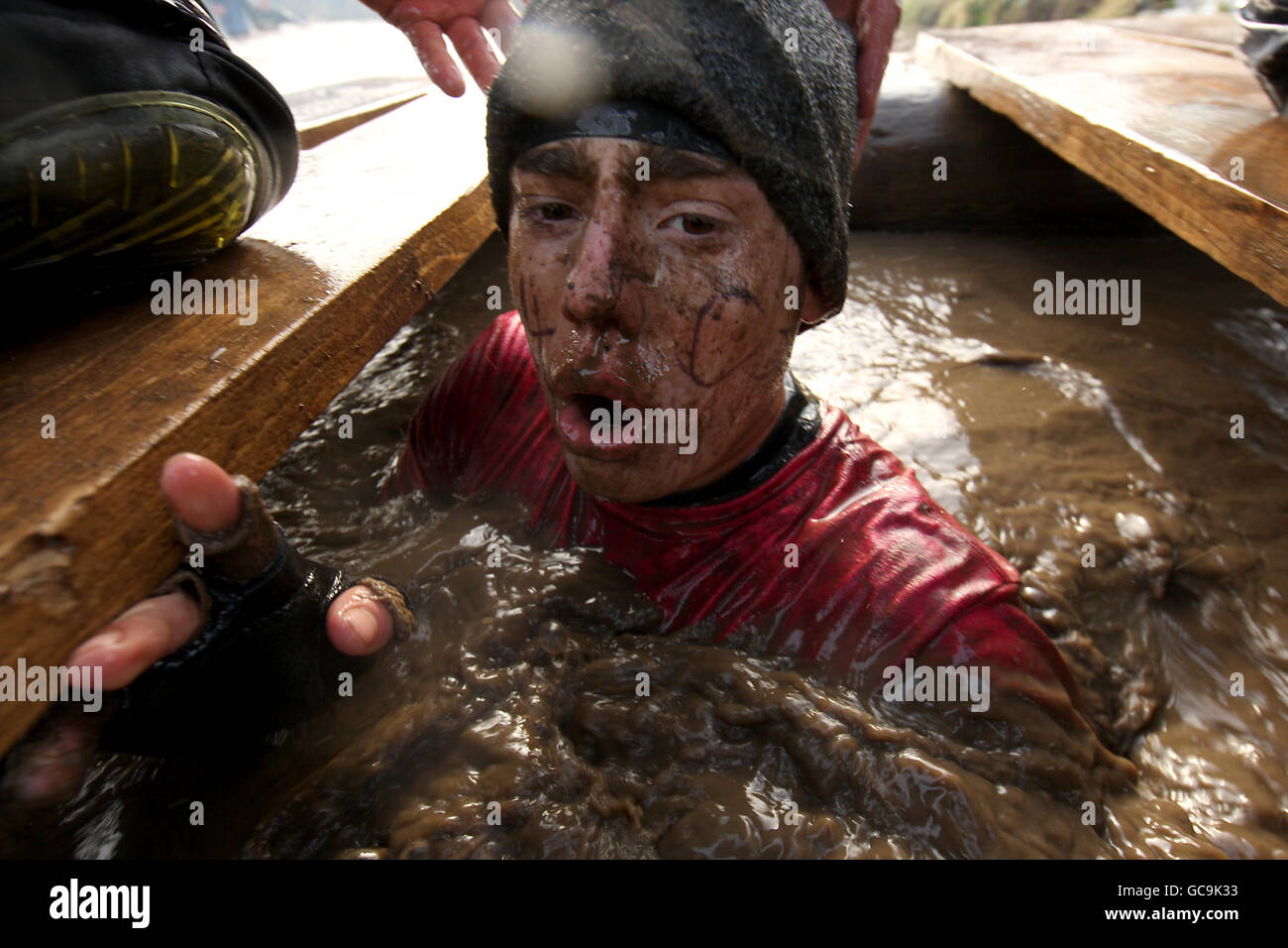 A competitor during emerges from the water tunnel during the Tough Guy ...