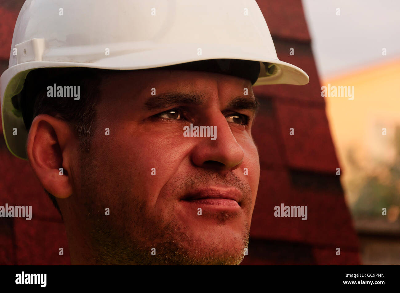 Roofing work, Builder in white hard hat of the engineer on background ...
