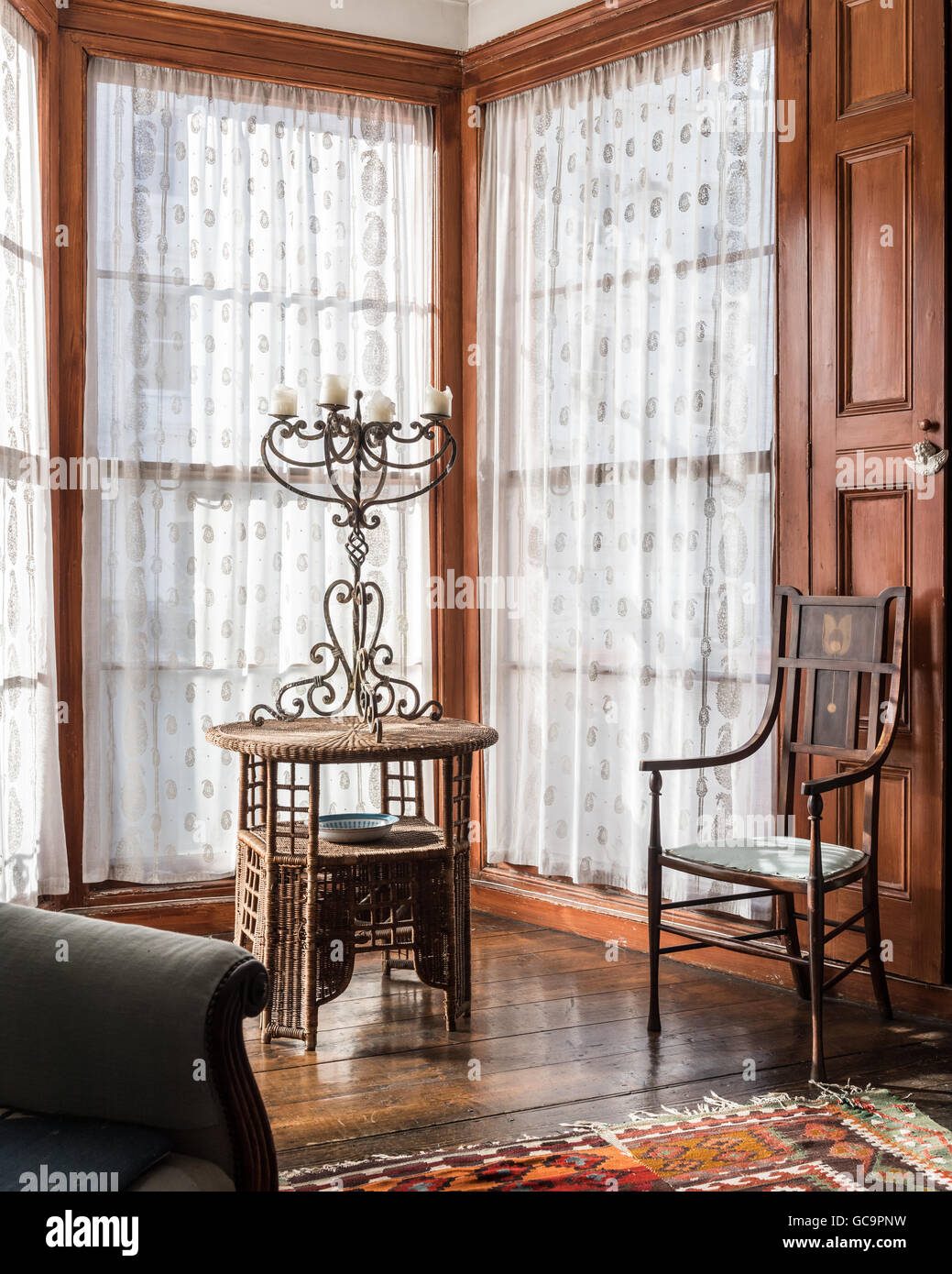 Metal candlestick on wicker side table in window of Nottinghill ...