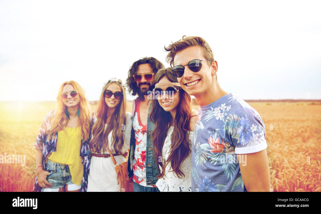 smiling young hippie friends on cereal field Stock Photo - Alamy