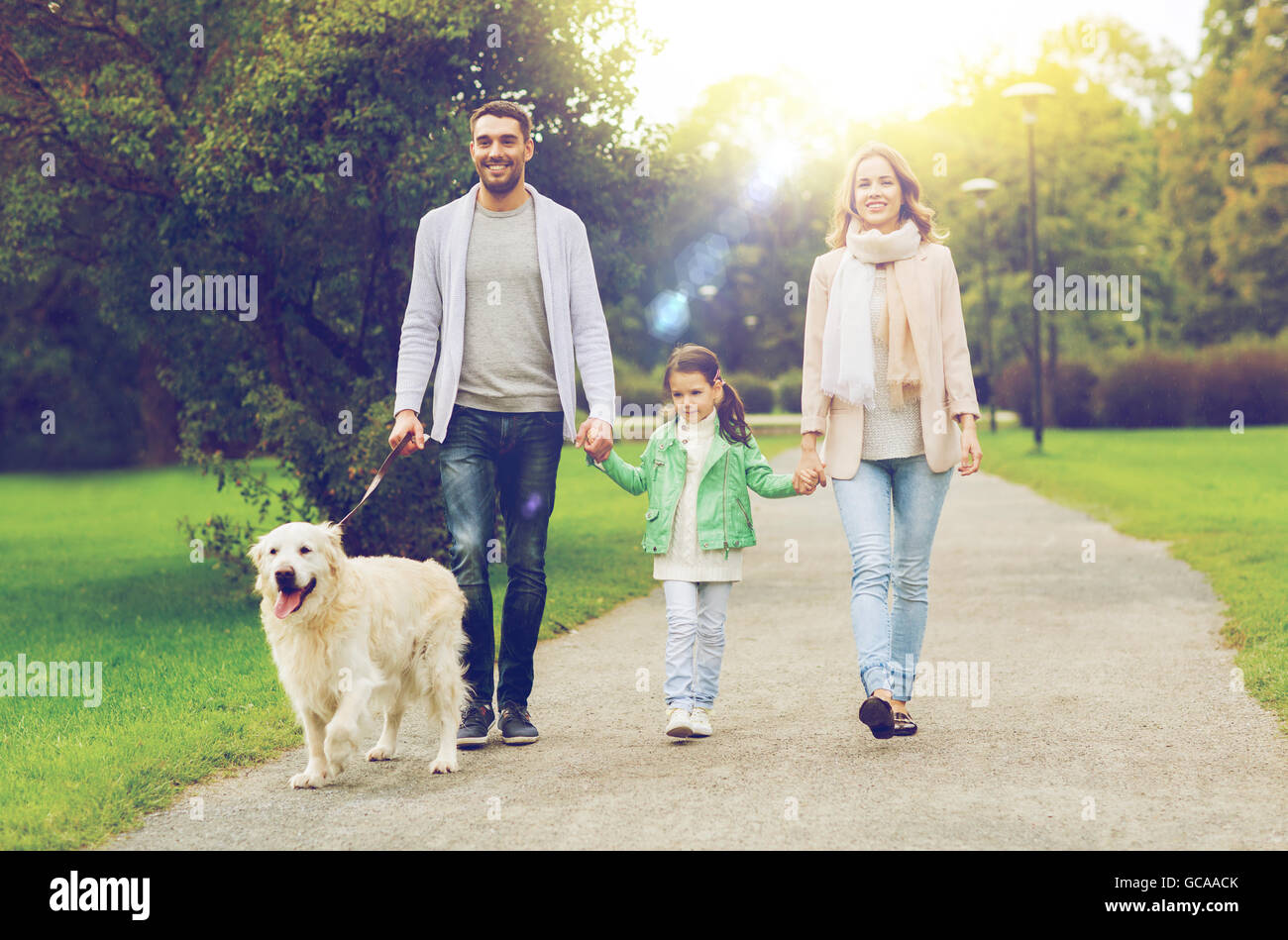happy family with labrador retriever dog in park Stock Photo - Alamy