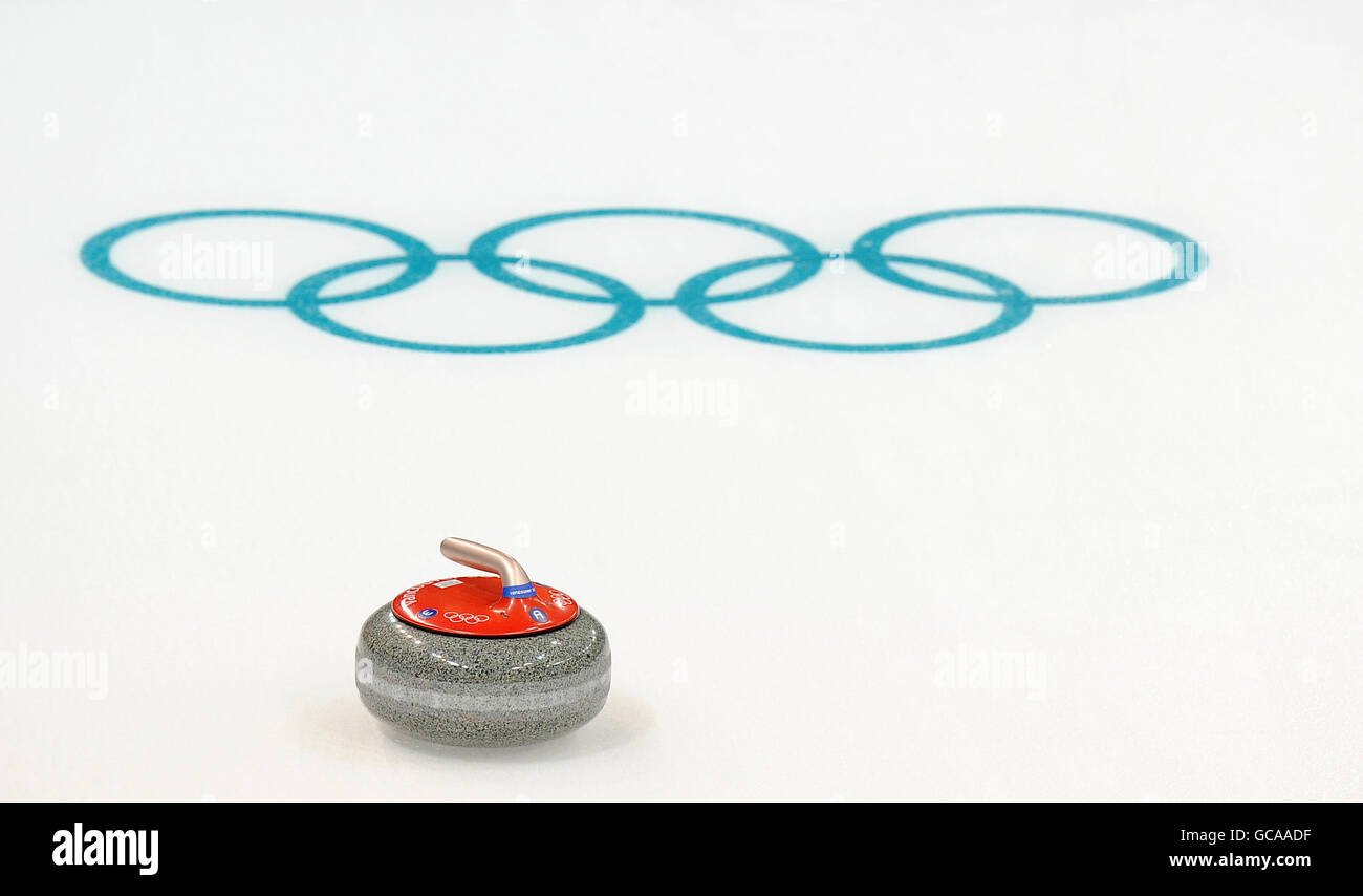 A view of the Curling stone next to Olympic rings on the ice in the ...