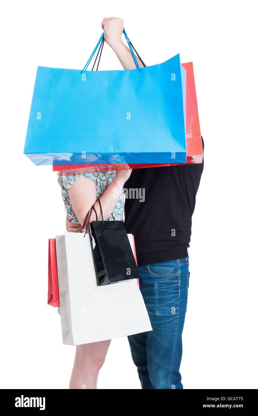 Romantic couple hugging and hiding behind shopping bags as affection ...