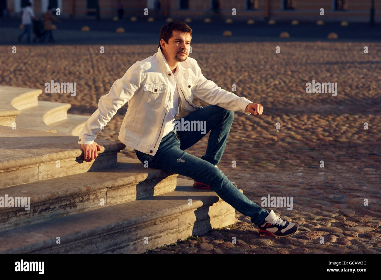 stylish man sitting on stairs Stock Photo - Alamy