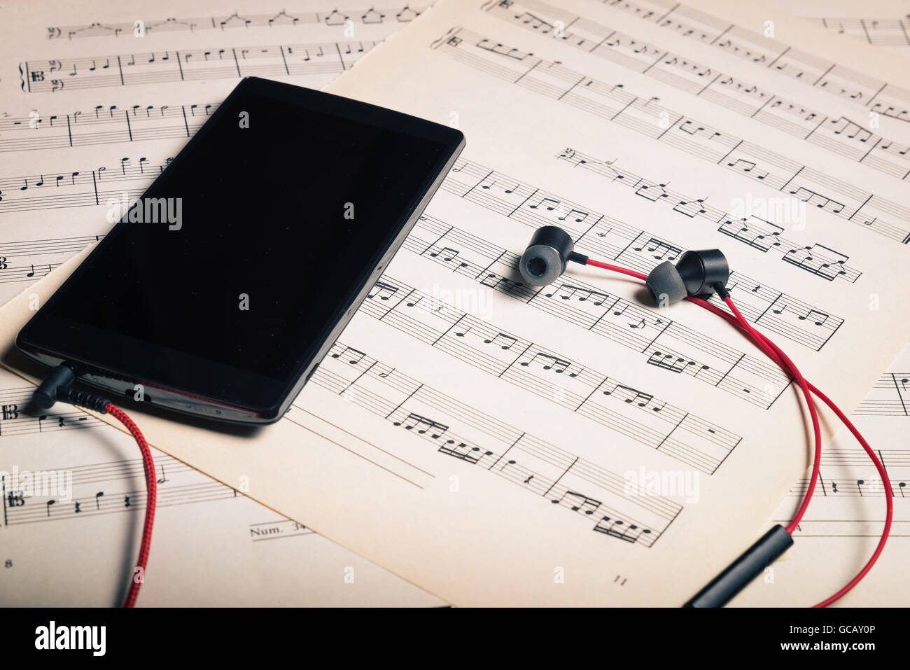 pictured black phone with headphones placed over sheets music Stock ...