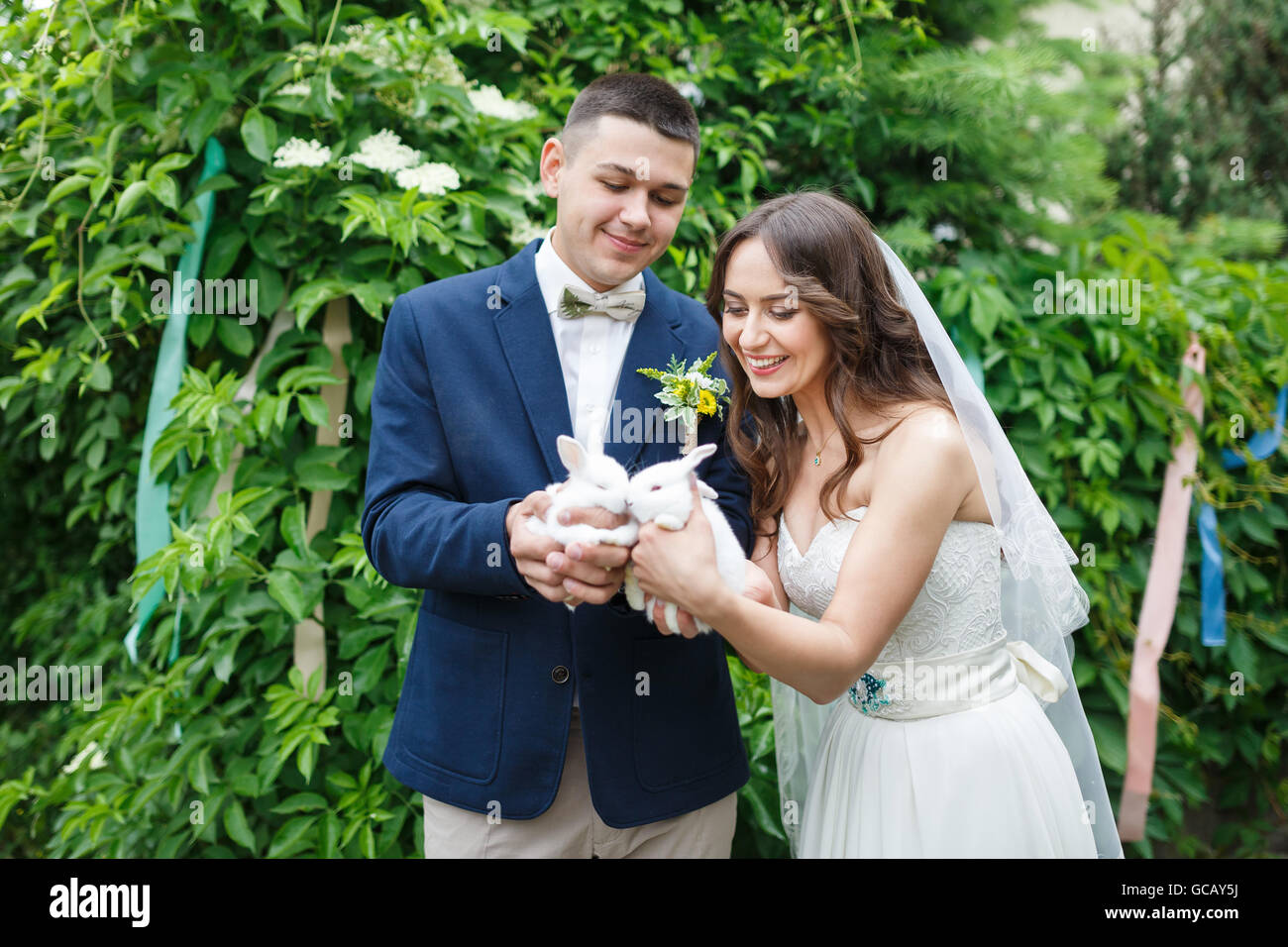 wedding couple are holding two small rabbits, summer time Stock Photo ...