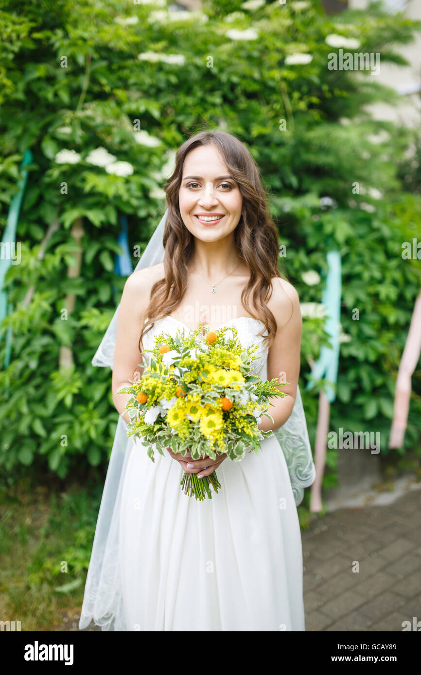 Happy bride holding a wedding bouquet, summer time Stock Photo - Alamy