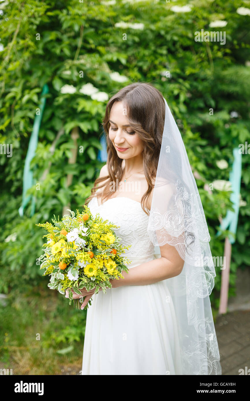 Happy bride holding a wedding bouquet, summer time Stock Photo - Alamy
