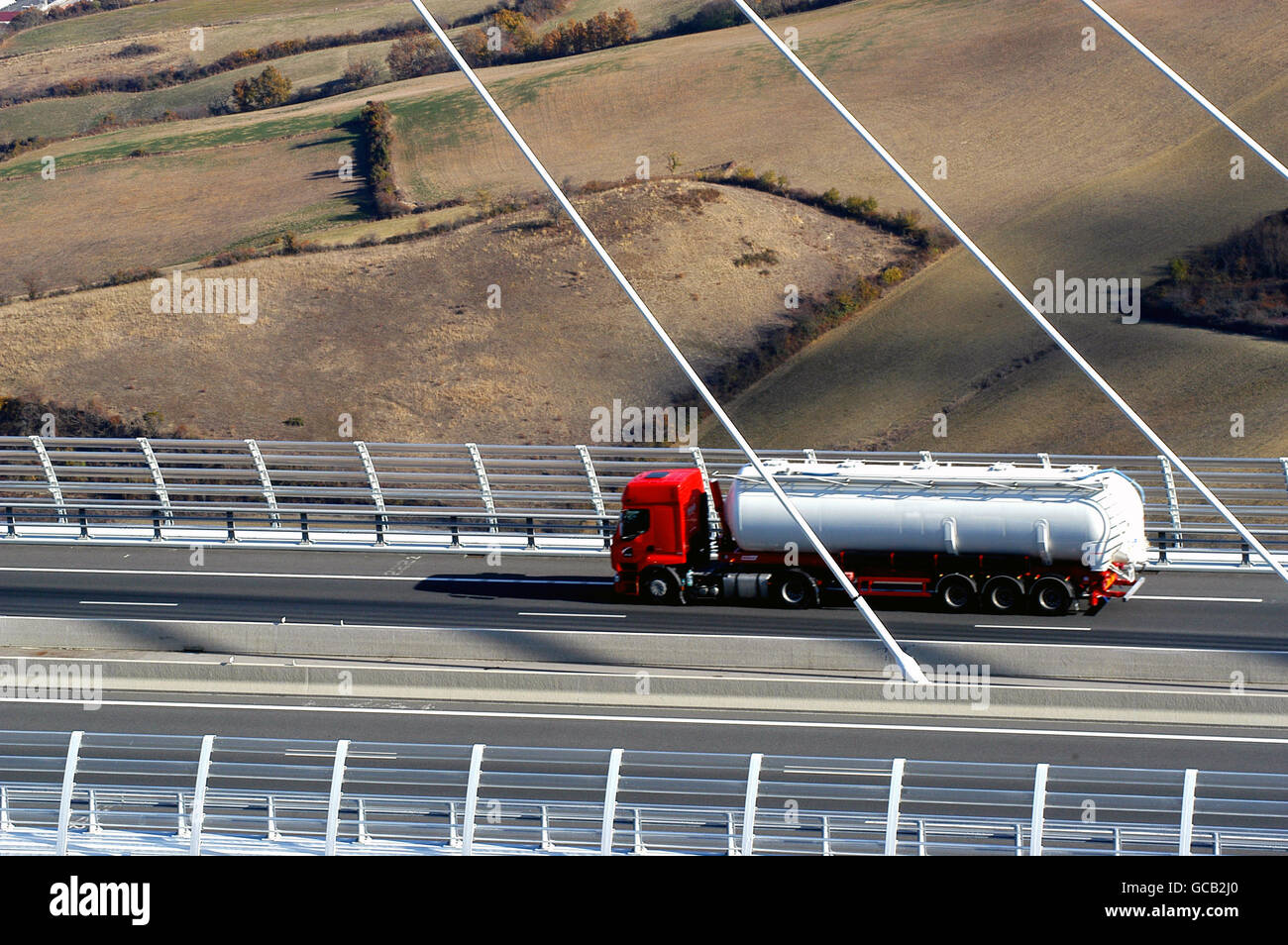 truck traveling on the highway and passing a high viaduct which ...