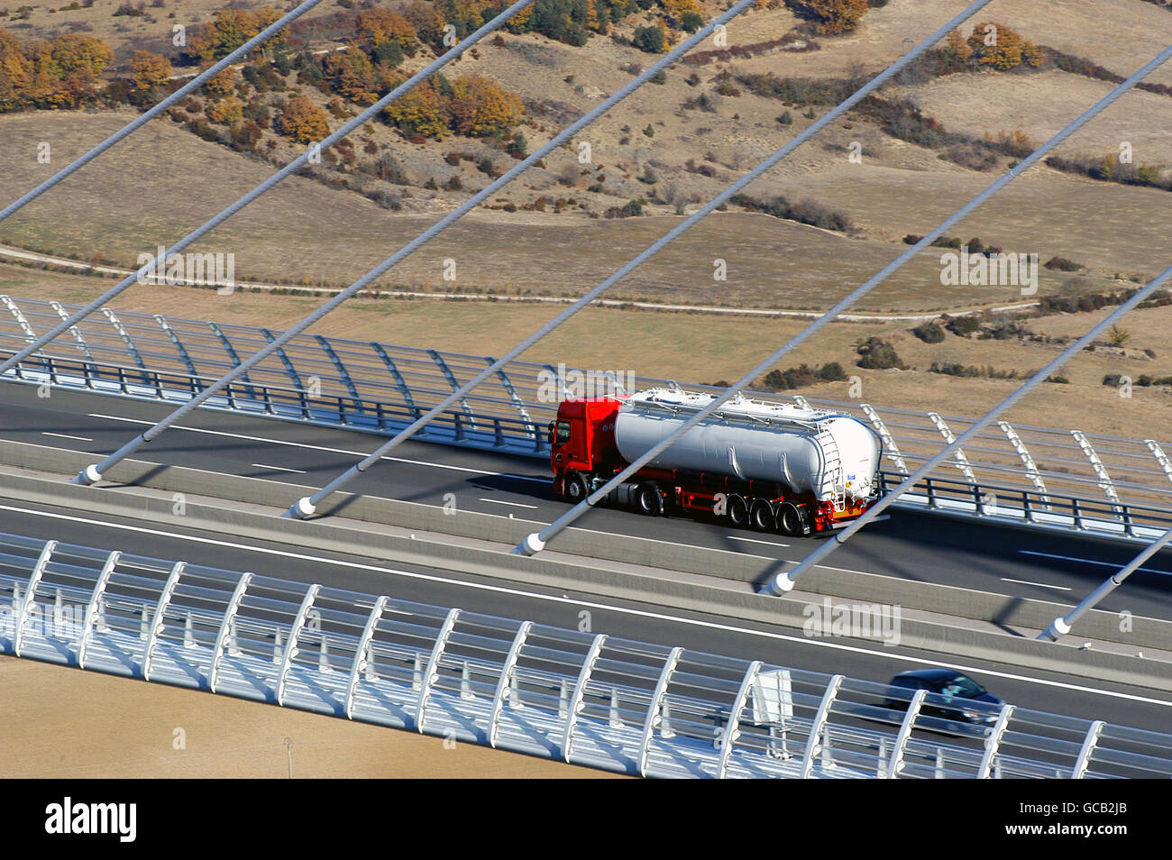 truck traveling on the highway and passing a high viaduct which ...