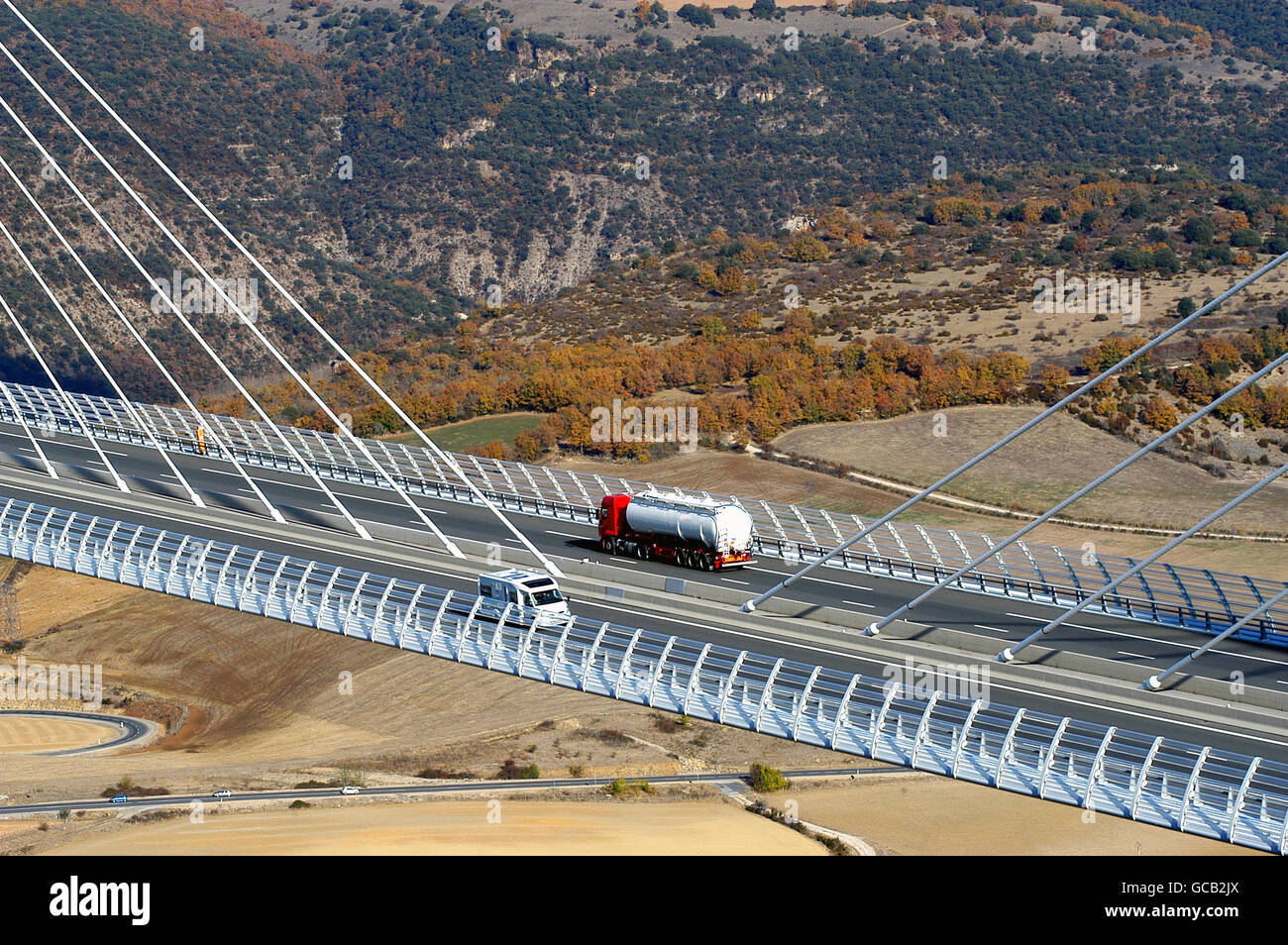 truck traveling on the highway and passing a high viaduct which ...