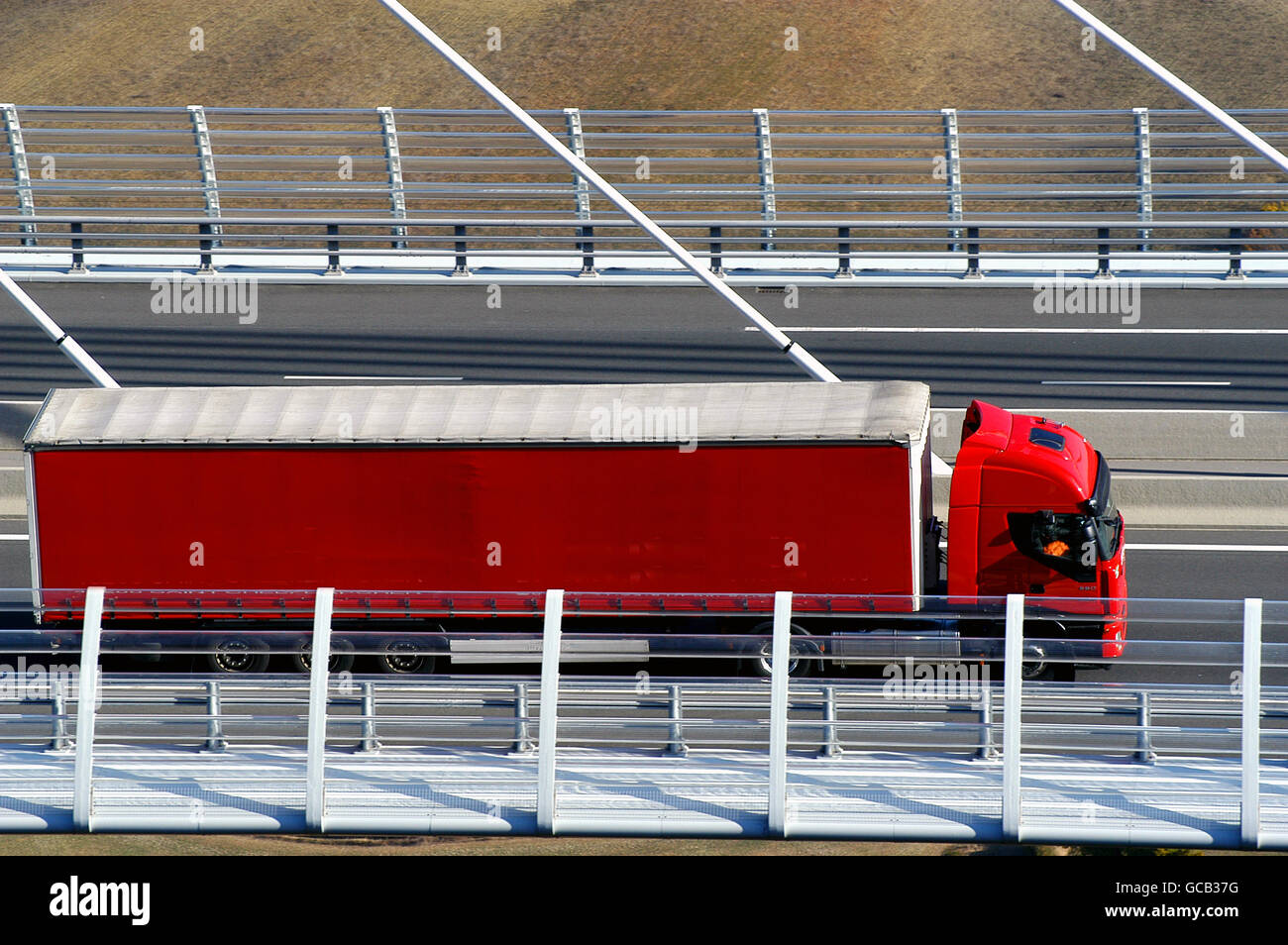 truck traveling on the highway and passing a high viaduct which ...