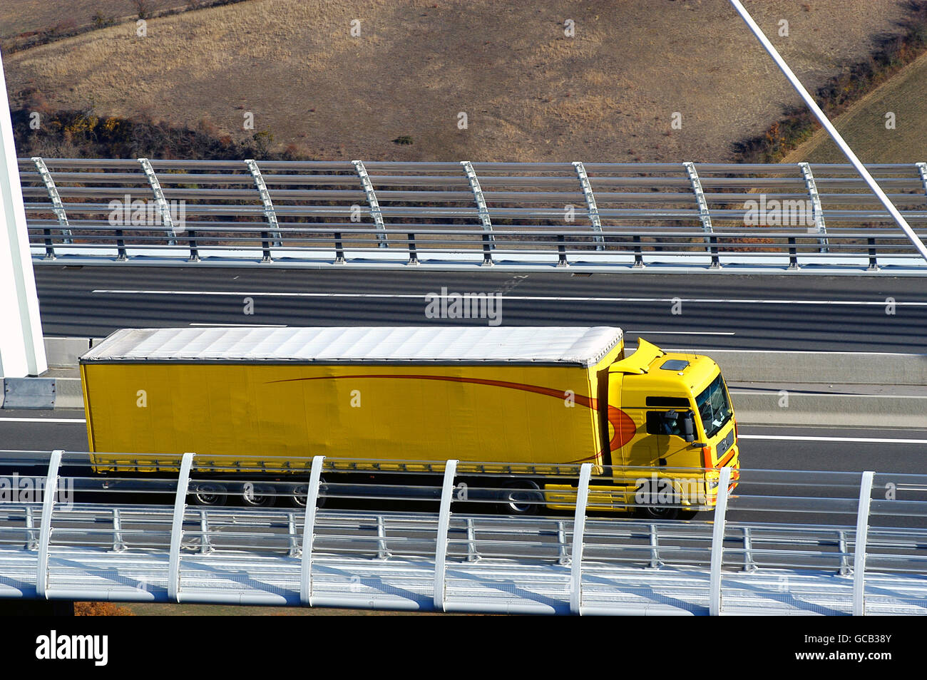 truck traveling on the highway and passing a high viaduct which ...