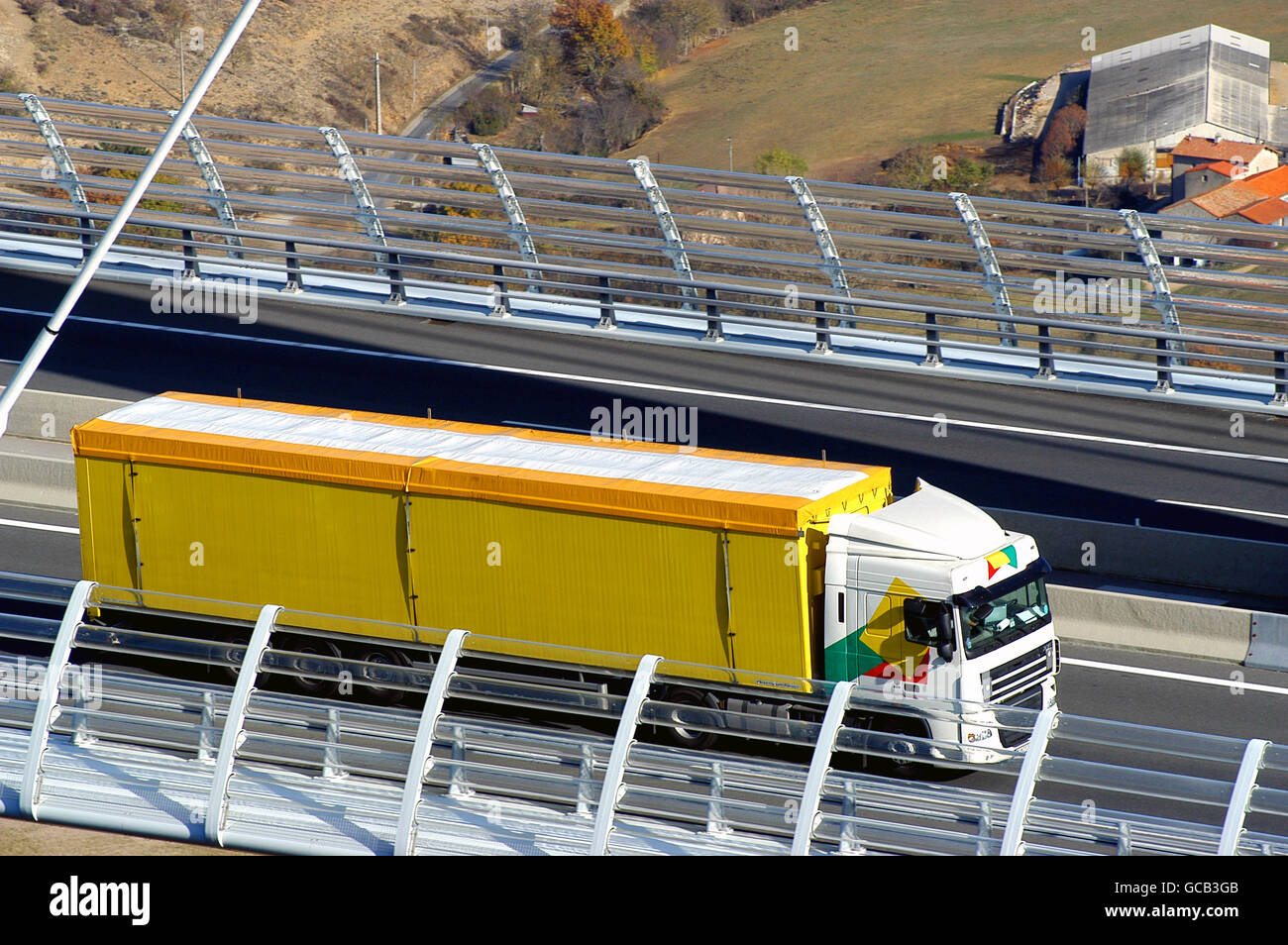 truck traveling on the highway and passing a high viaduct which ...
