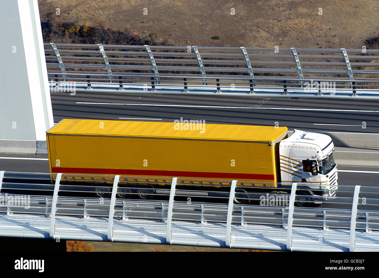 truck traveling on the highway and passing a high viaduct which ...