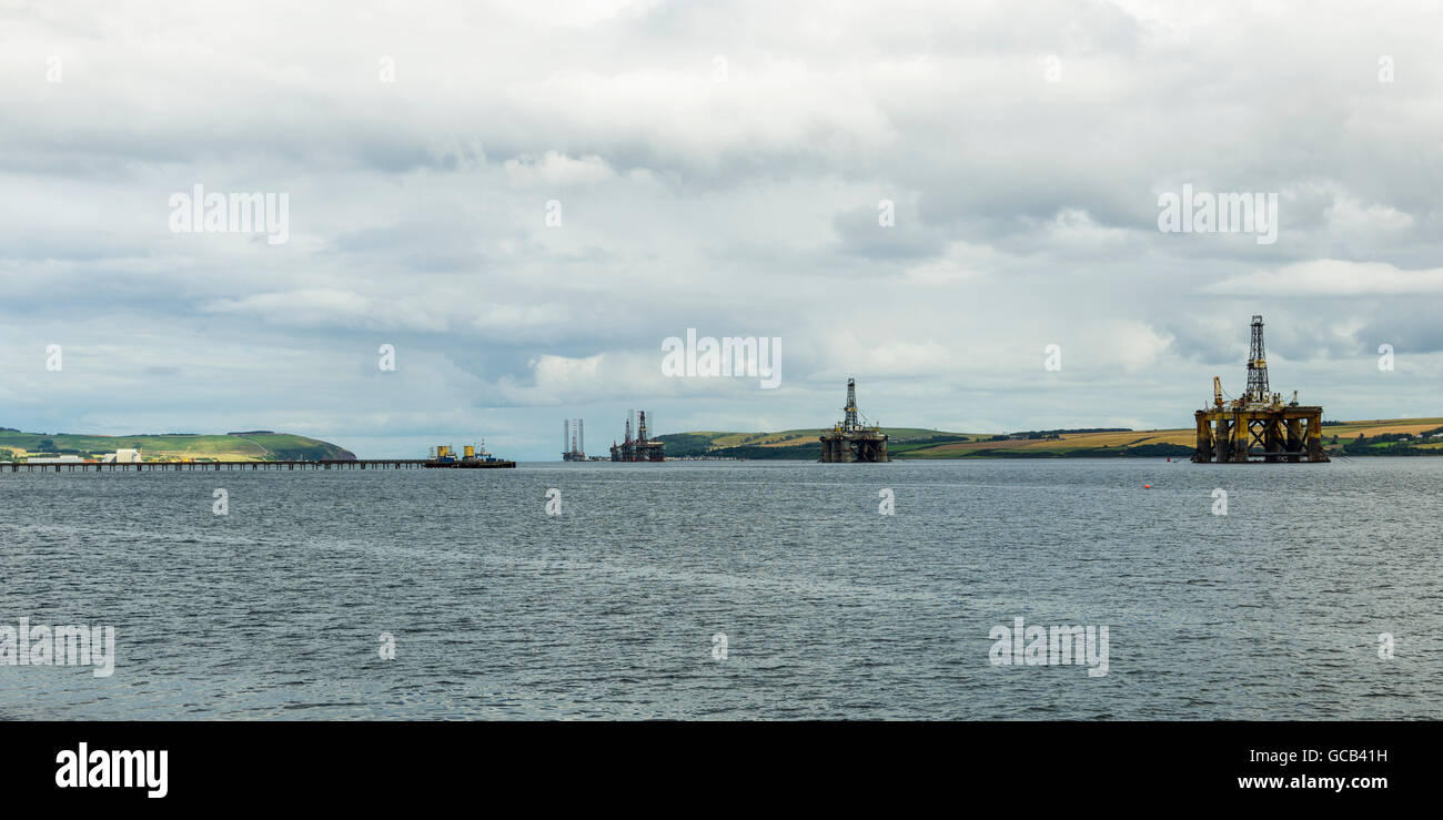 Drilling rigs off the coast with farmland in the background ...