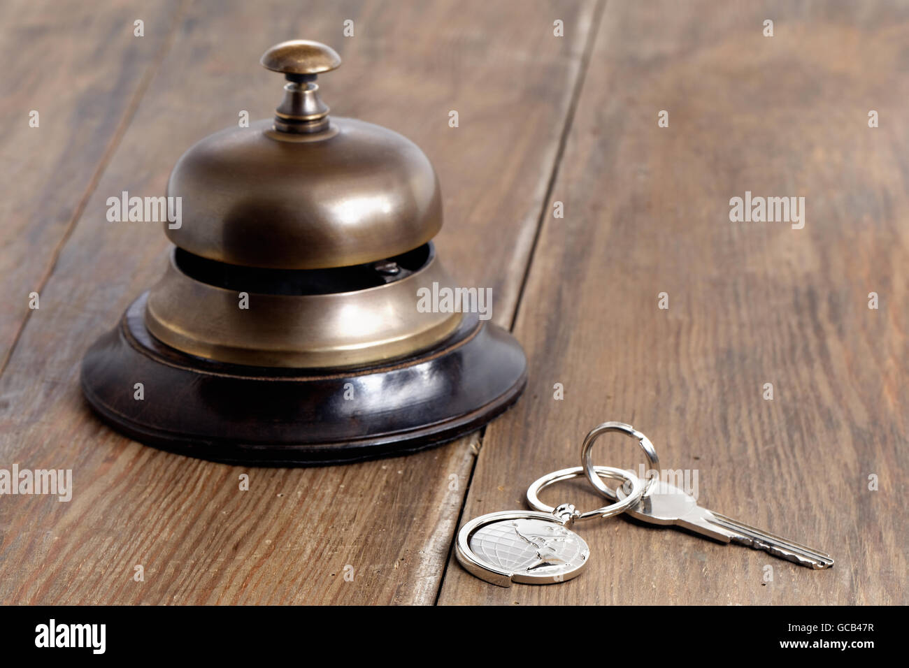 Reception bell and hotel key on a reception desk Stock Photo - Alamy