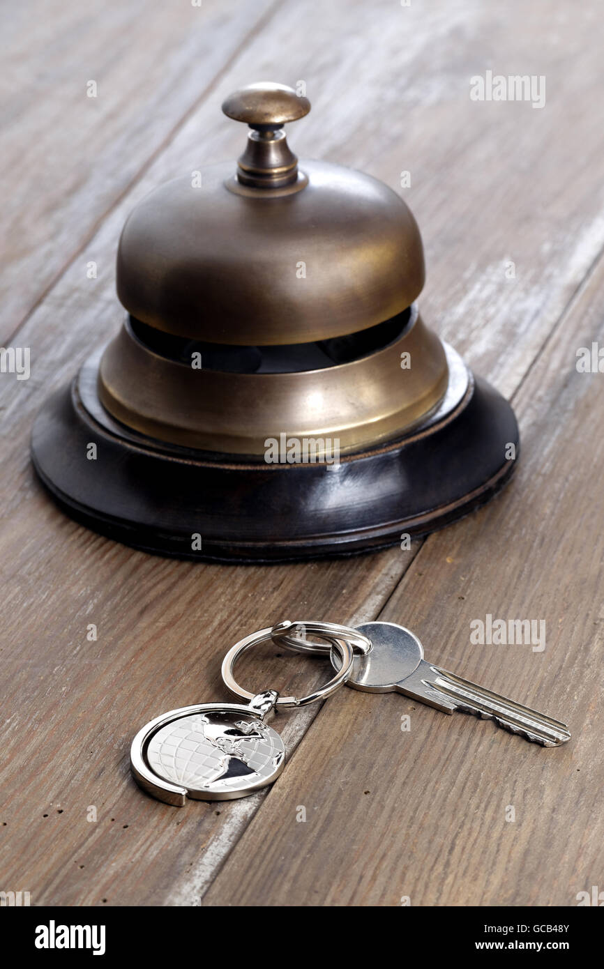 Reception bell and hotel key on a reception desk Stock Photo - Alamy