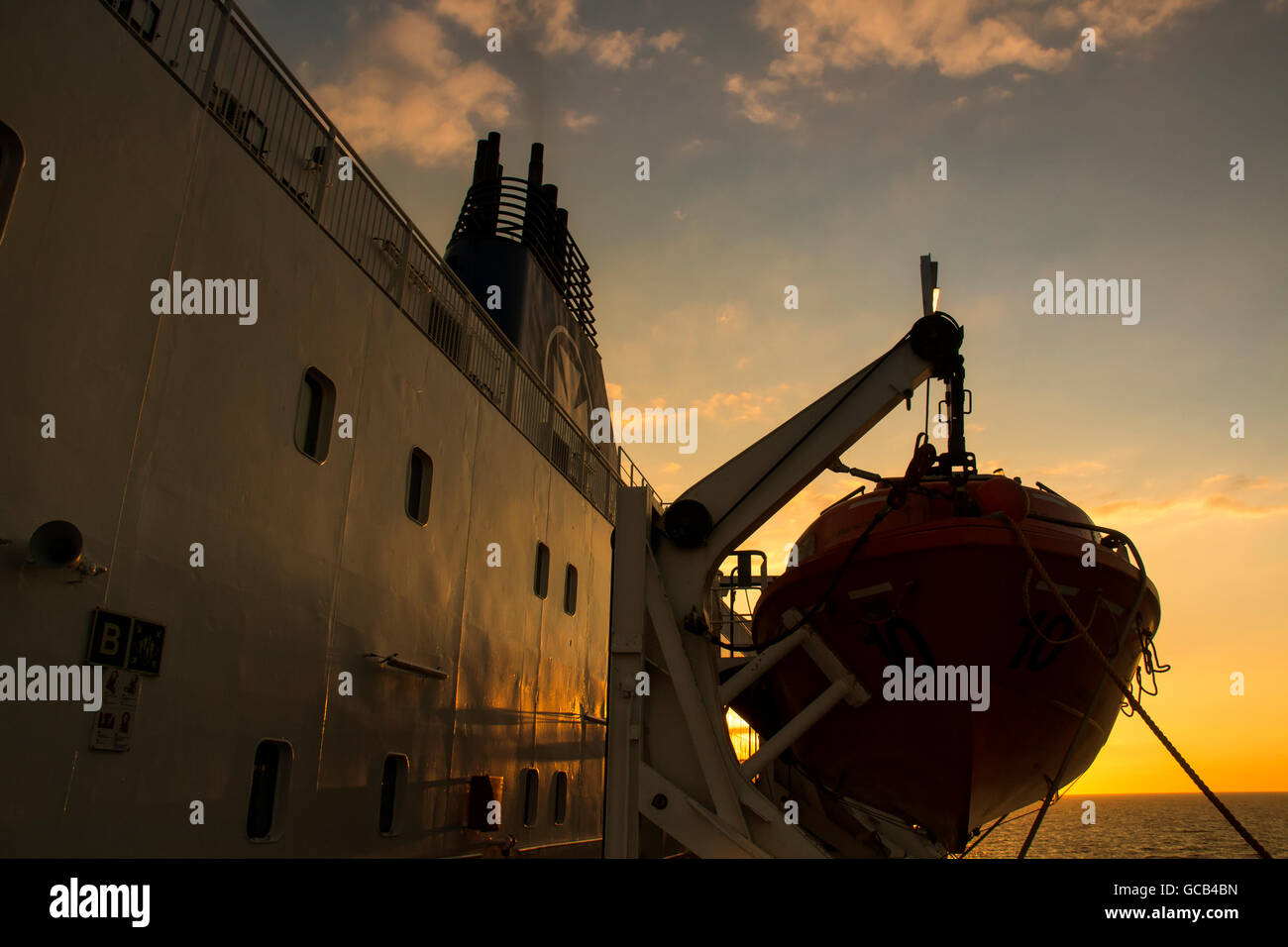 A ship is lifted out of the water with a sunset over the North Sea in ...