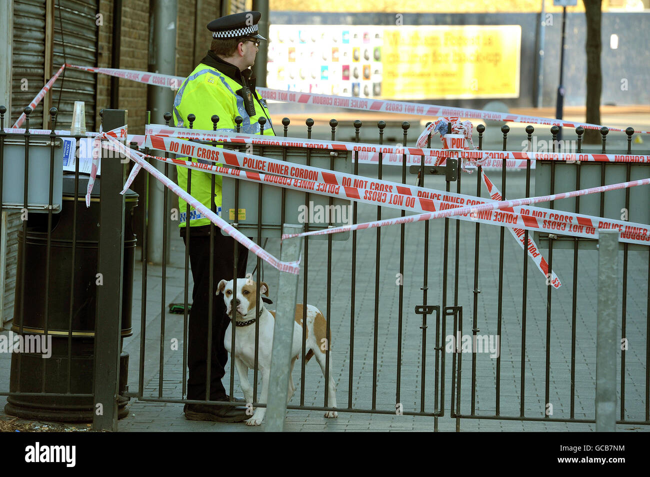 A Police officer and his dog man a cordoned off area between the Bus ...