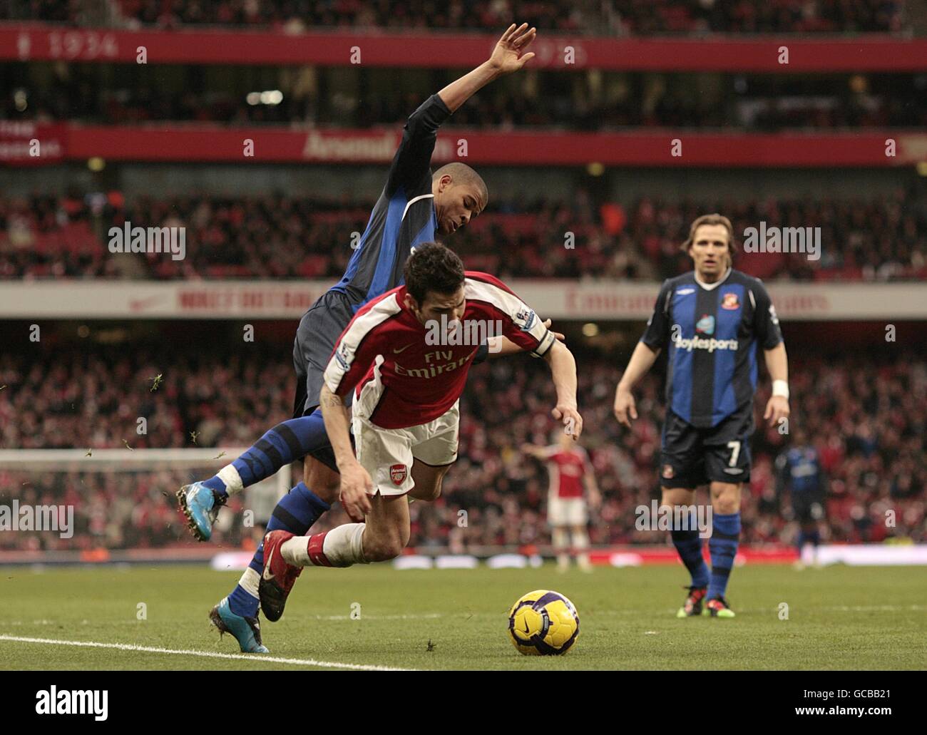 Arsenal's Francesc Fabregas (centre) goes to ground in the area after a ...