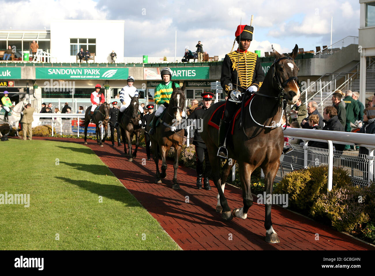 Horses and jockeys are led around the parade ring hi-res stock ...
