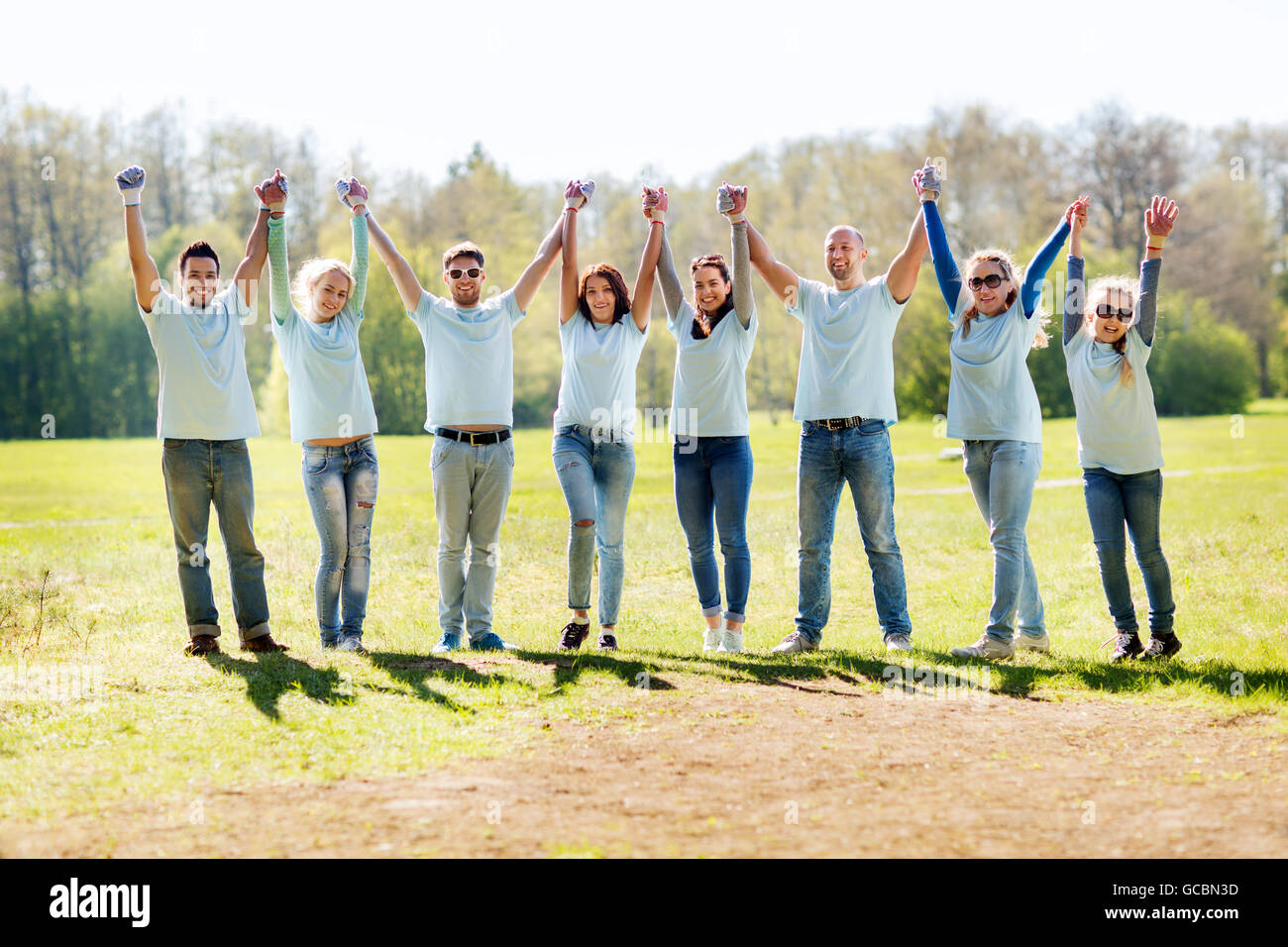 group of volunteers celebrating success in park Stock Photo - Alamy